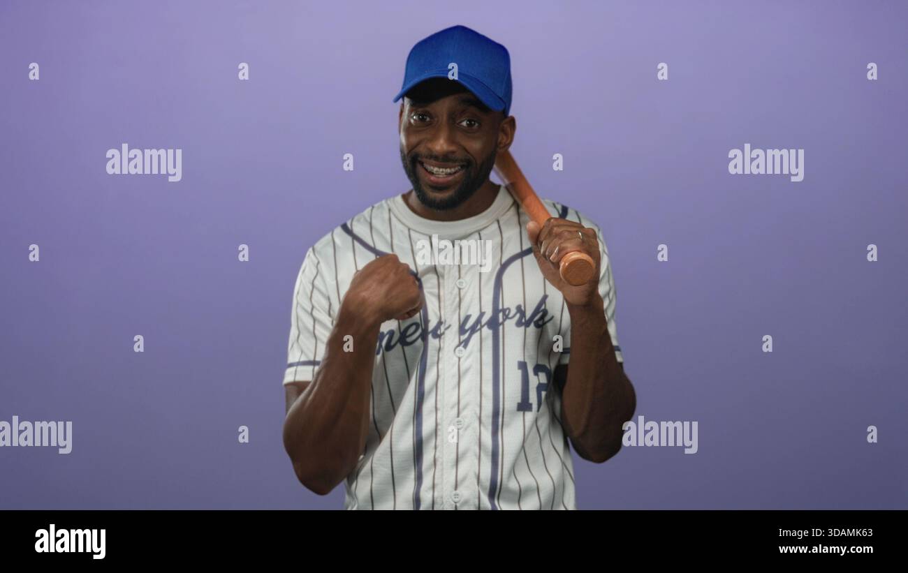 Man wearing pinstripe jersey and blue cap holding baseball bat over ...