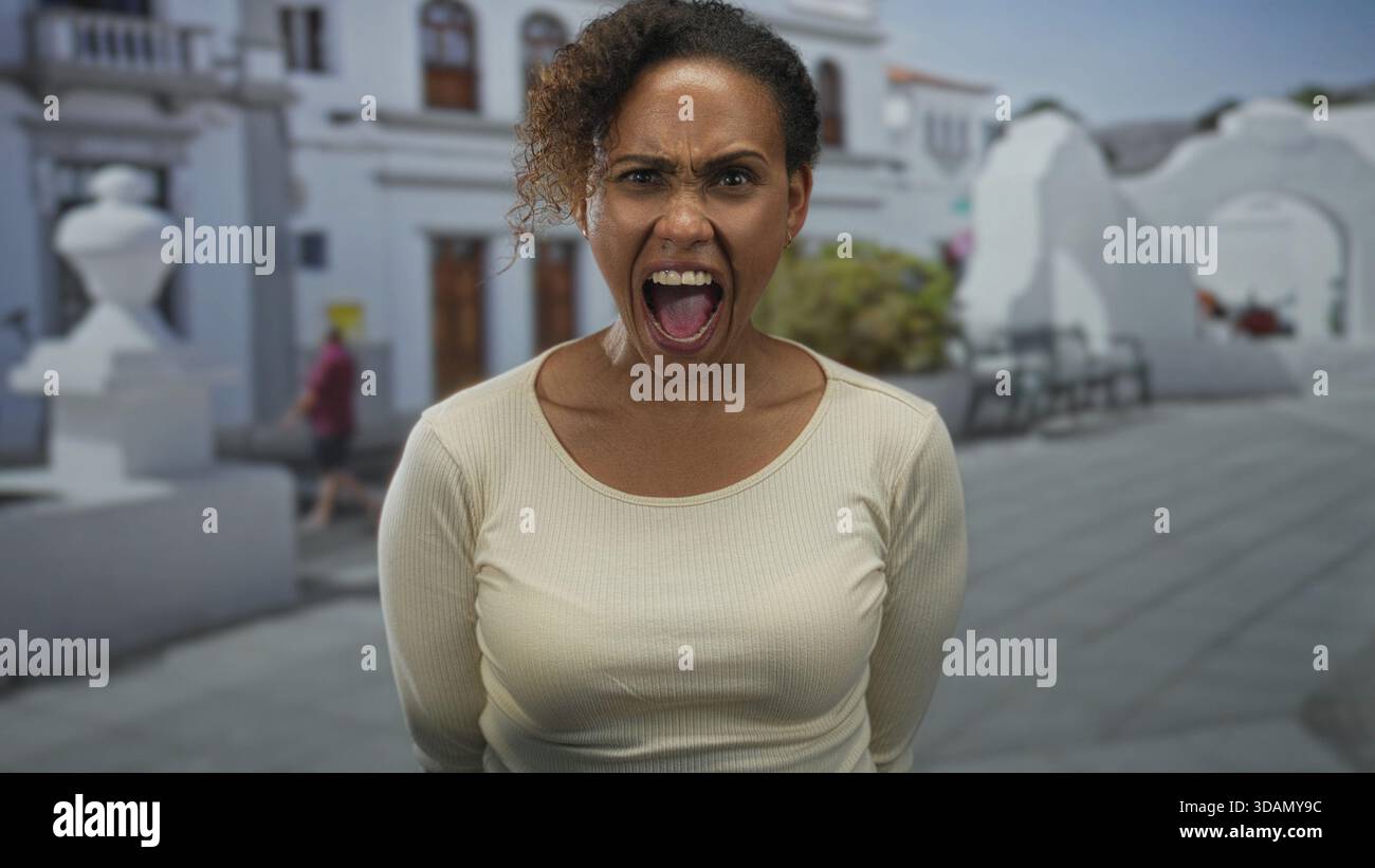 Woman mouth open shouting on street in front of white building, tongue ...