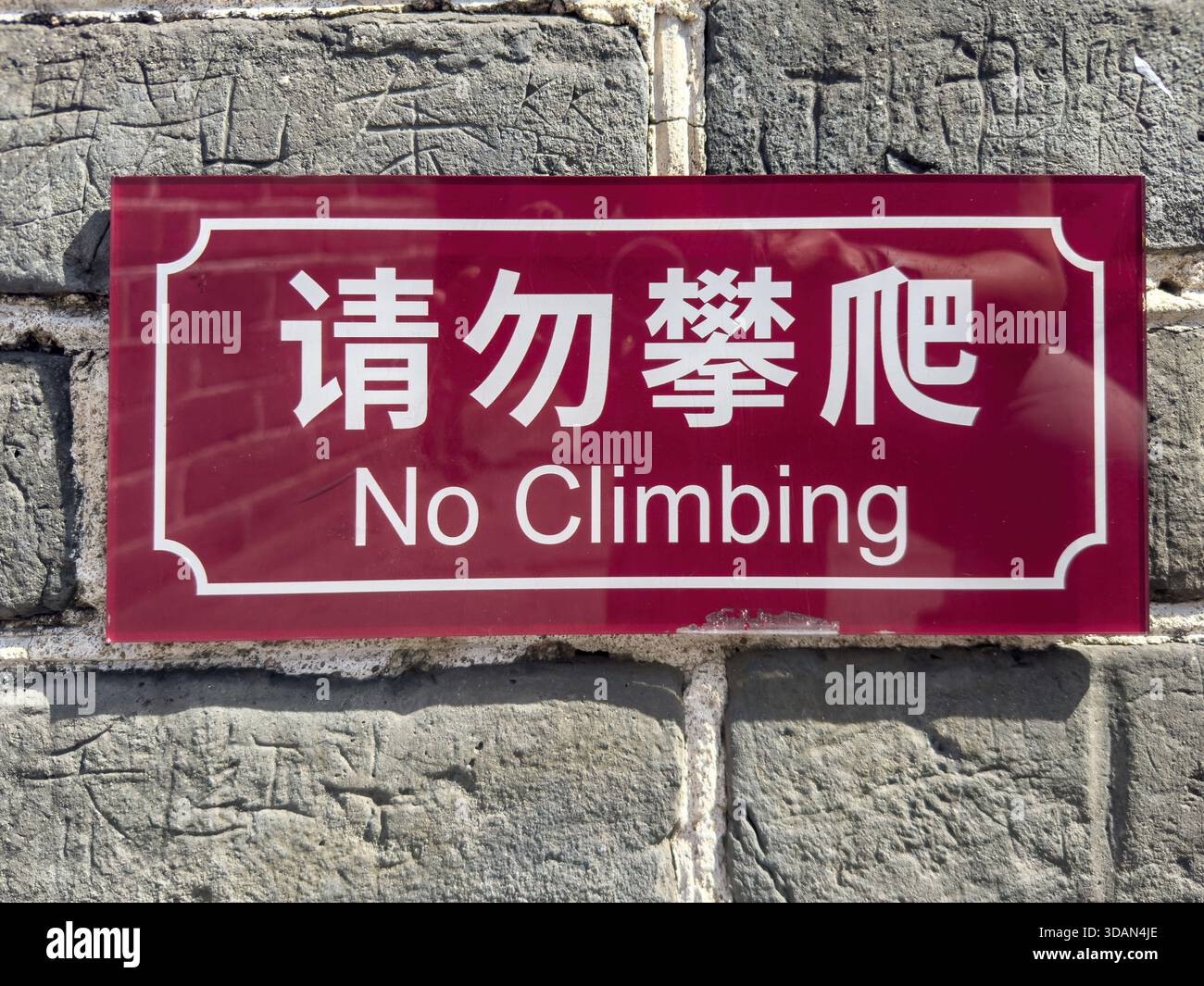 "No Climbing" Warning sign in Chinese and English on a stone wall at ...