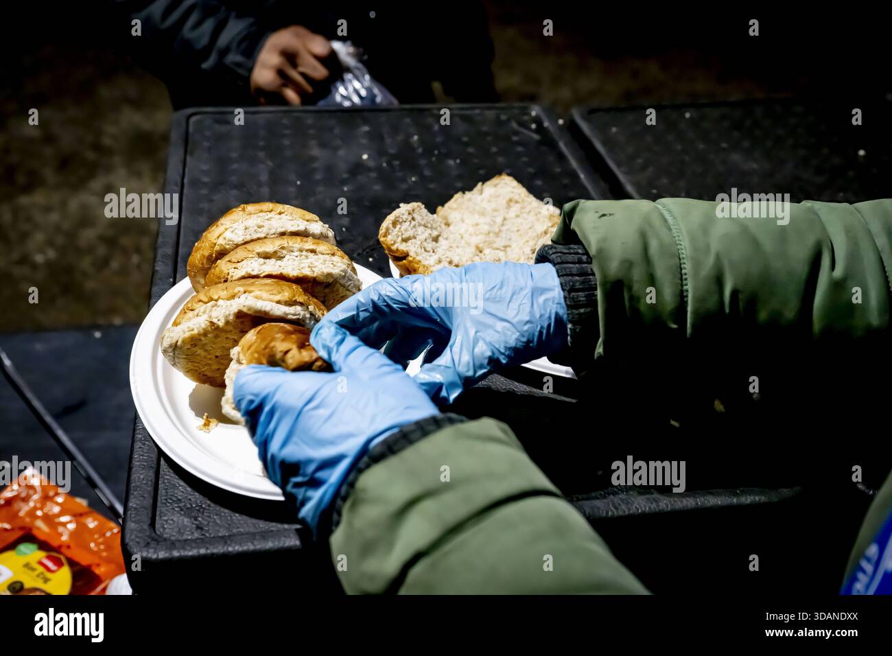 THE HAGUE - Homeless people receive a hot meal from aid workers in the ...