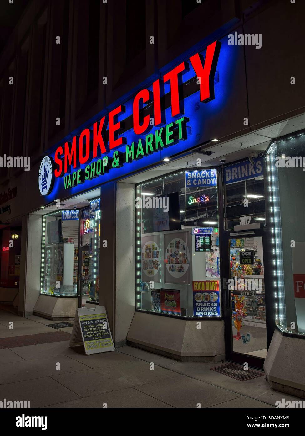 Neon lit fascia sign over storefront after dark in downtown Bay City ...