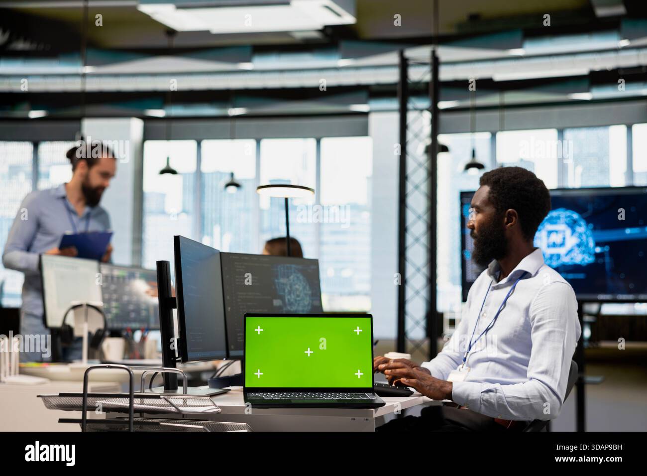 Engineer in office using AI on green screen laptop to streamline app ...