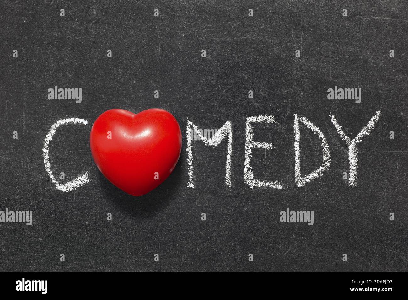 Comedy word handwritten on blackboard with heart symbol instead of O ...