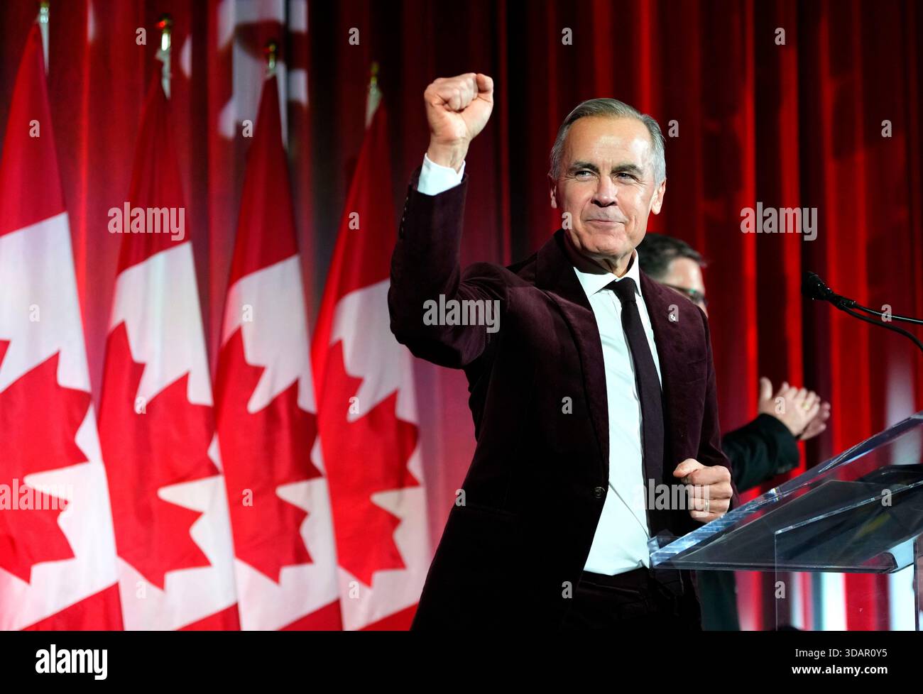 Prime Minister Mark Carney pumps his fist as he arrives to deliver ...