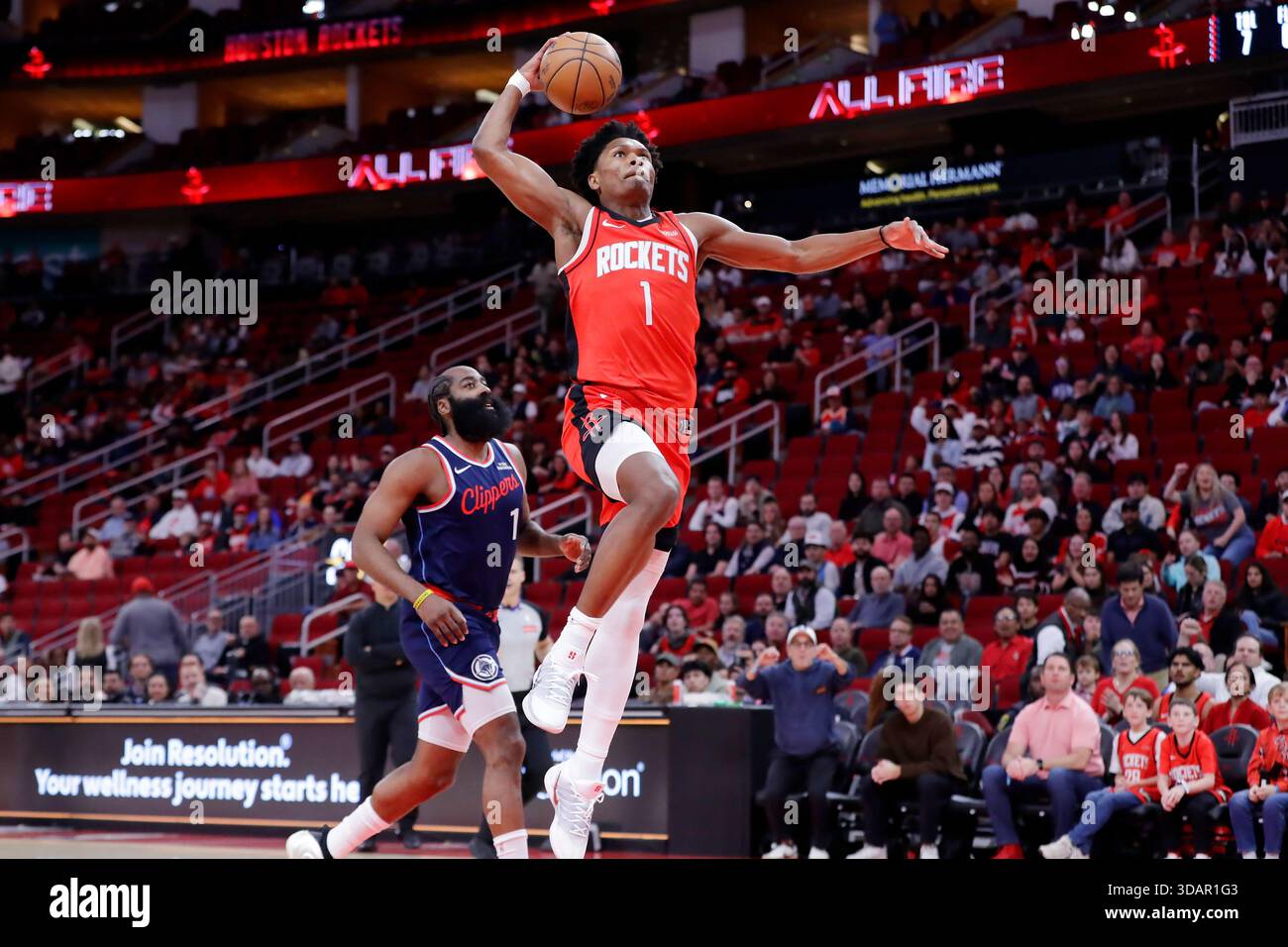 Houston Rockets guard Amen Thompson, right, goes up to dunk in front of ...