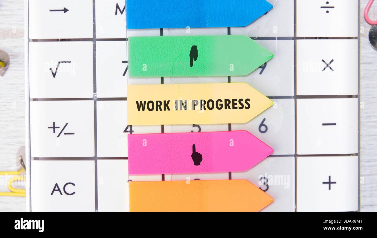 A calculator features colorful sticky notes, including one boldly ...