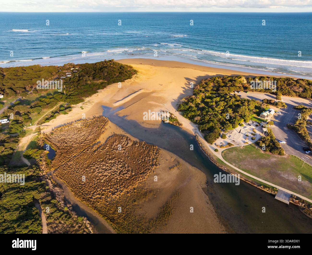 Aerial view of the ocean off a coastal rivermouth blocked by a sand ...