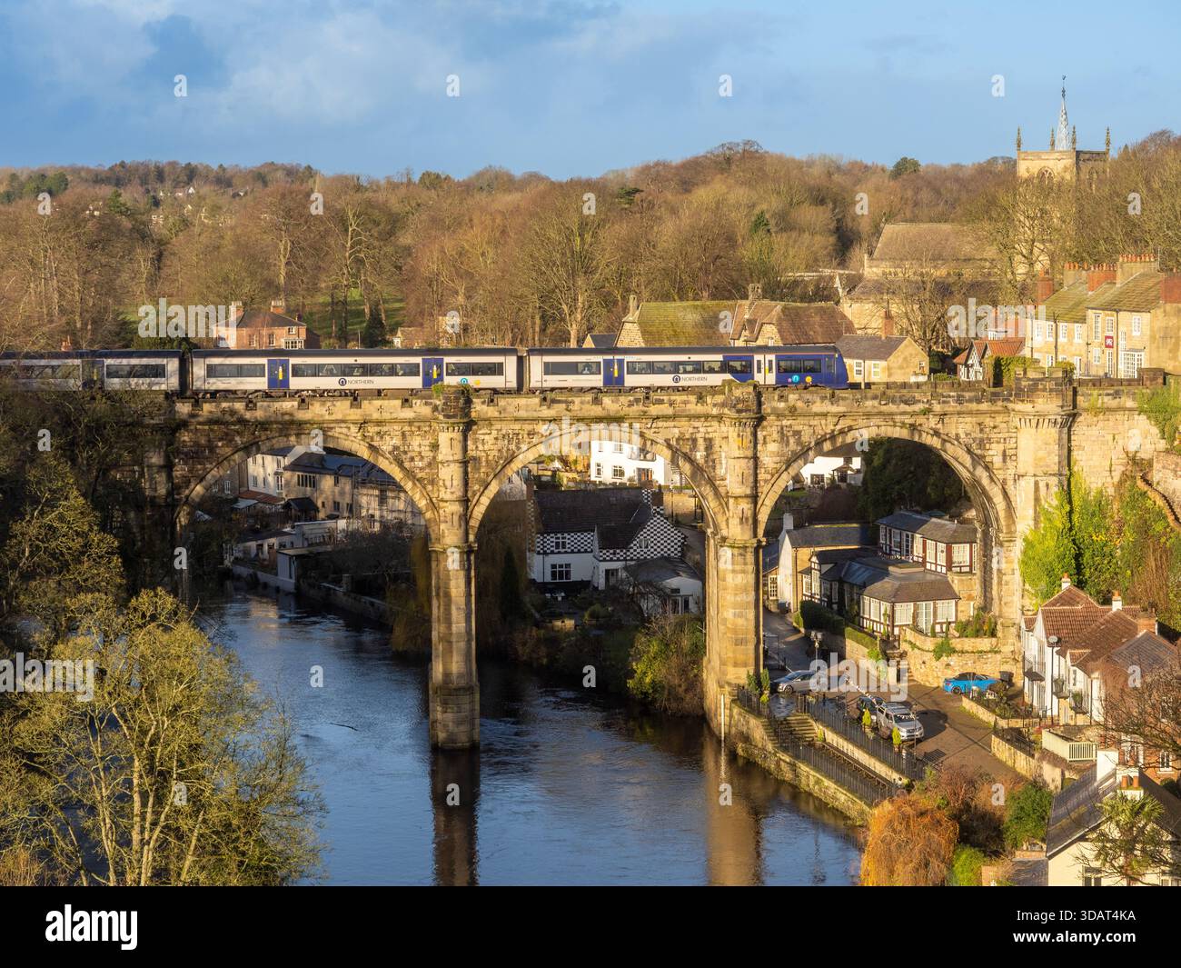 A Northern Rail train crossing the historic stone arches of the ...