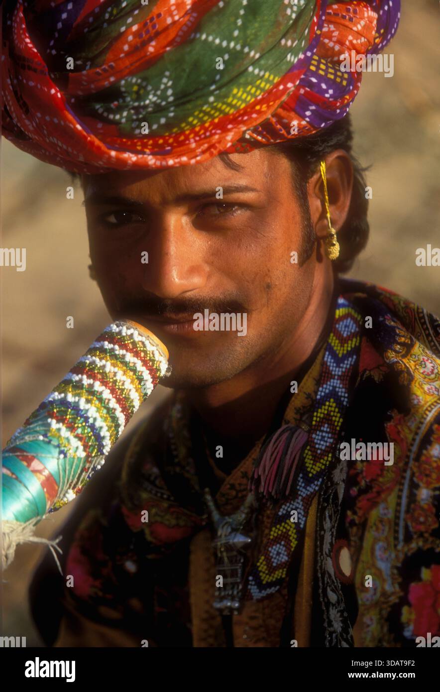 A Kalbeliya Gypsy man playing his Poongi flute in the Rajasthan Desert ...
