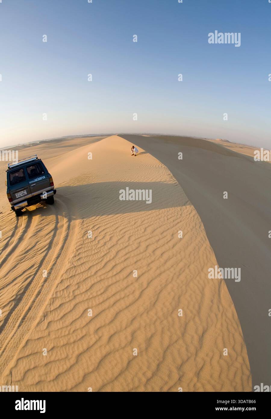 Egyptian man rests on sand dune at sunset in El-Siwa, Egypt Stock Photo ...