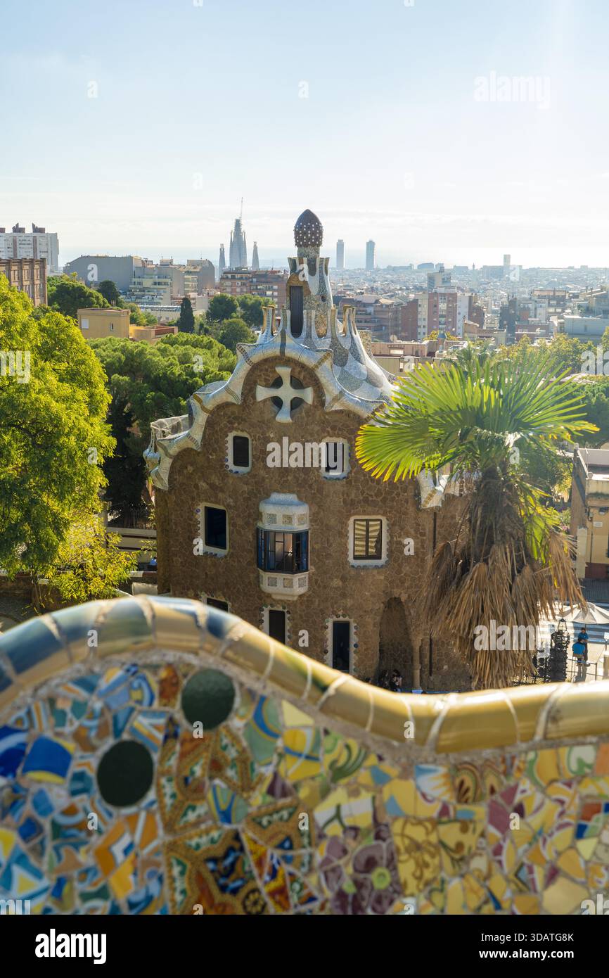 View of an iconic mosaic bench curves, framing a whimsical building ...