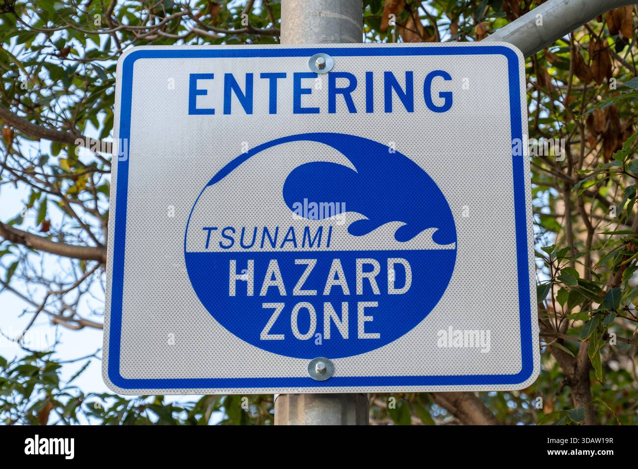 Entering tsunami hazard zone warning sign with wave symbol on metal ...