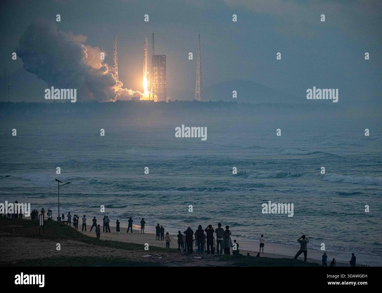 (251212) -- HAIKOU, Dec. 12, 2025 (Xinhua) -- People watch a rocket ...