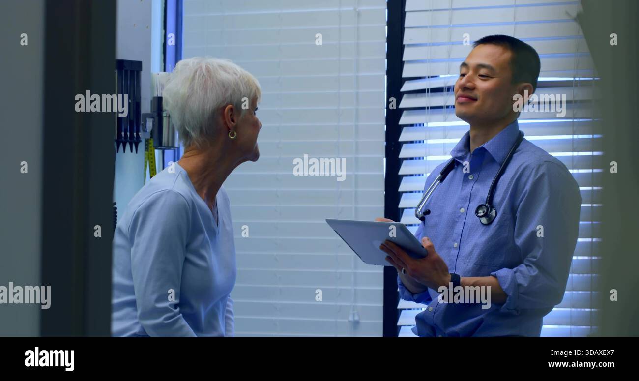 Discussing clinician in blue shirt with tablet and stethoscope ...