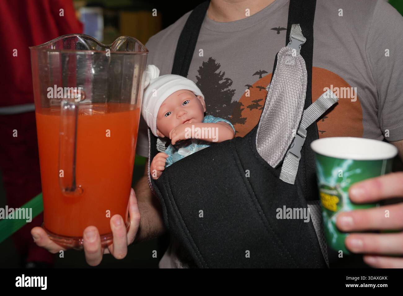 A dart fan carries a baby doll as he watches the World Darts ...