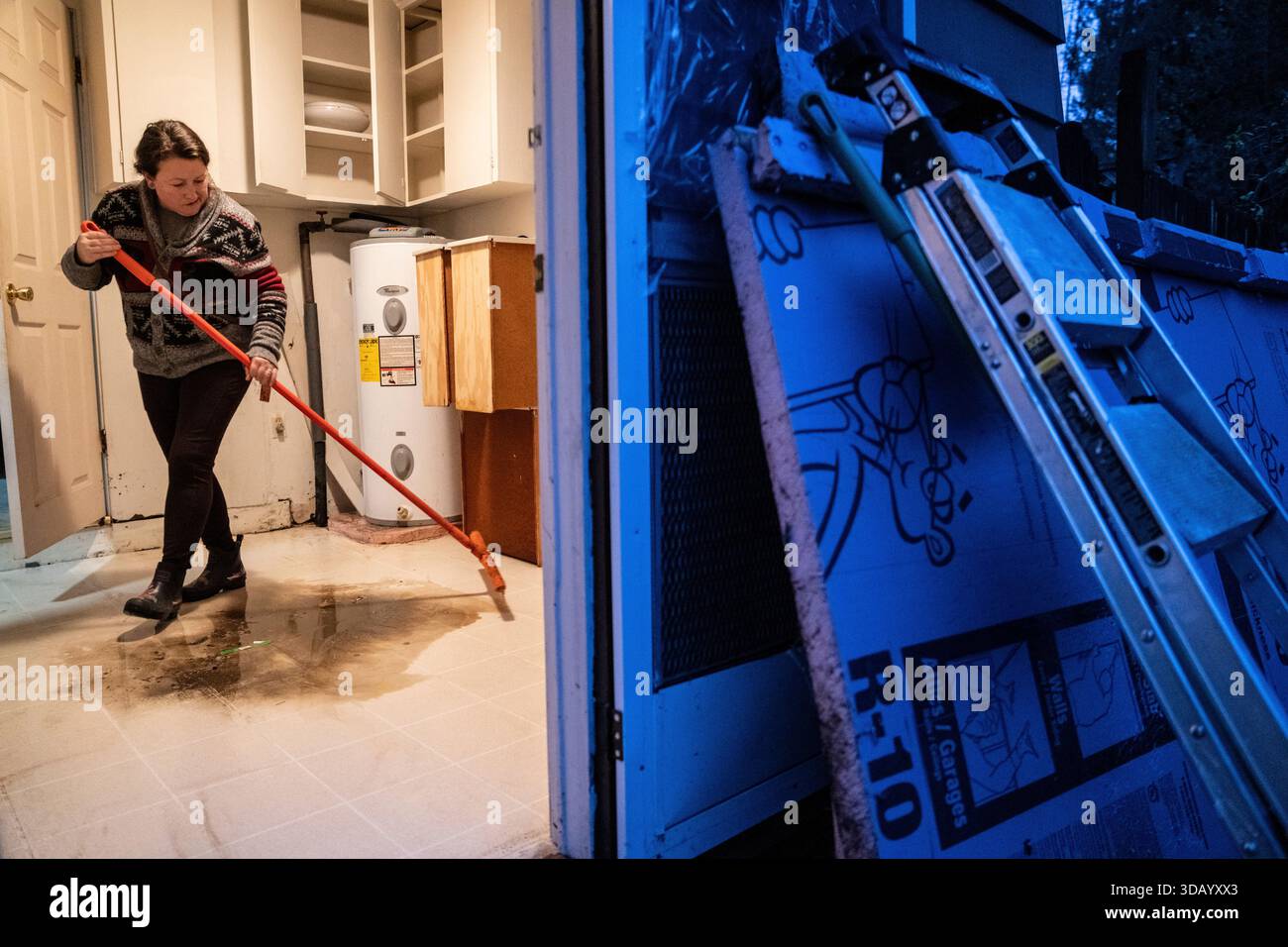 Debi Flores cleans the floors of a house owned by her father after ...