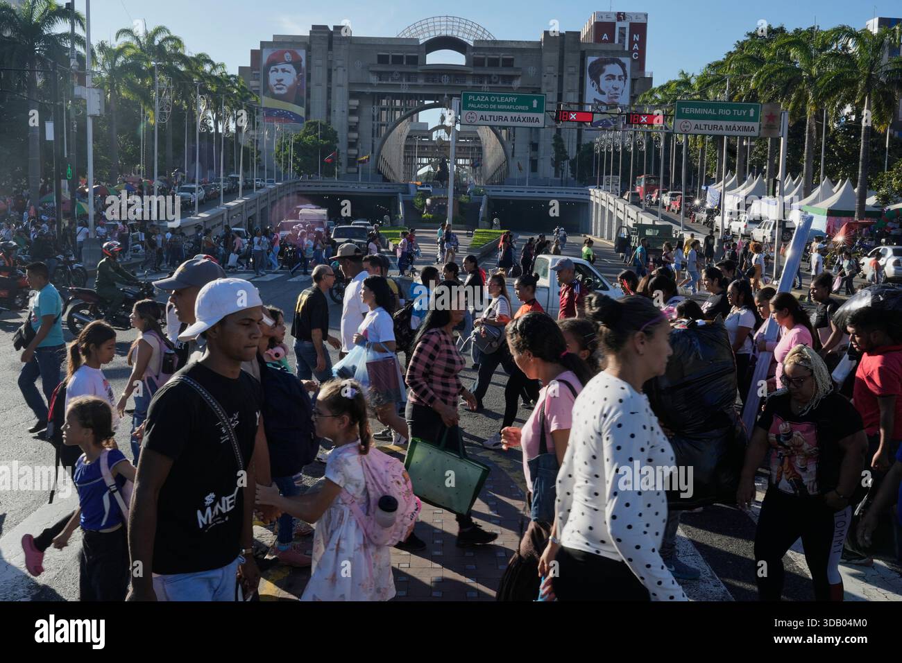 Pedestrians walk past a monument featuring the late president Hugo ...