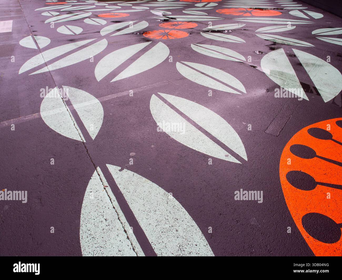 Painted pavement featuring stylized white leaves and orange floral ...