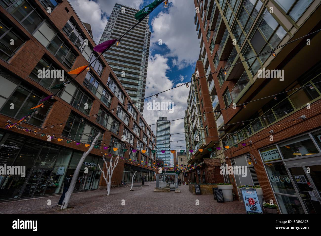 String lights and colorful flags hang above a pedestrian courtyard ...