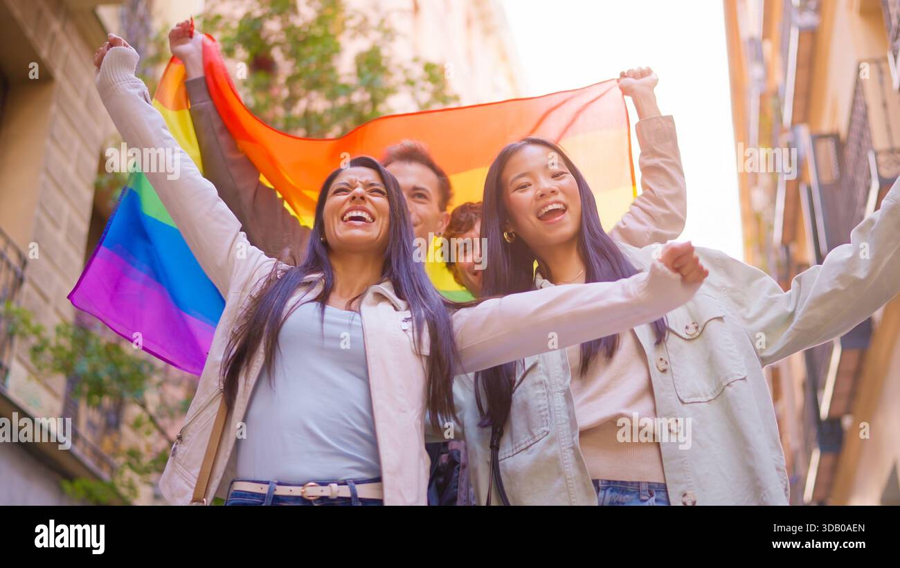 Young diverse friends holding rainbow hi-res stock photography and ...