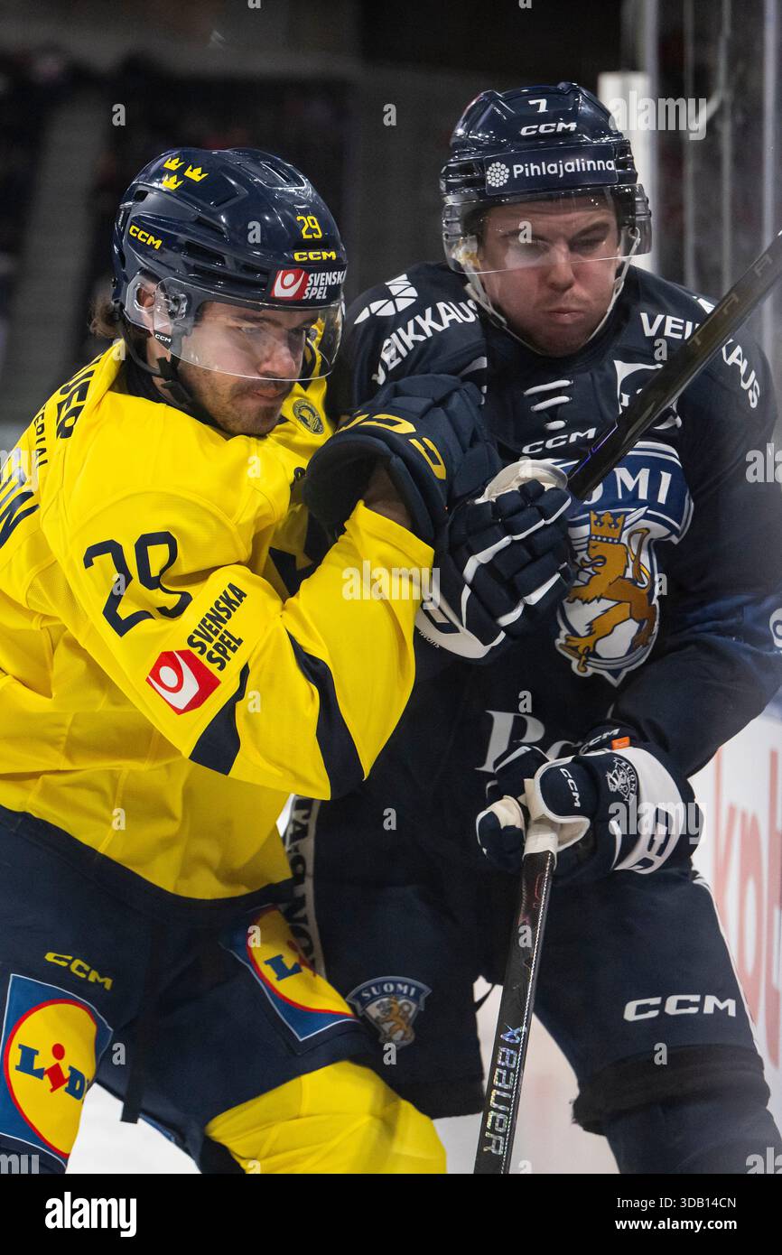 Sweden's Axel Andersson, left, fights for the puck against Finland's ...