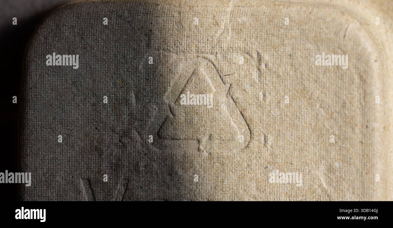 Close-up of embossed recycling symbol on cardboard. Close-up shot of an ...