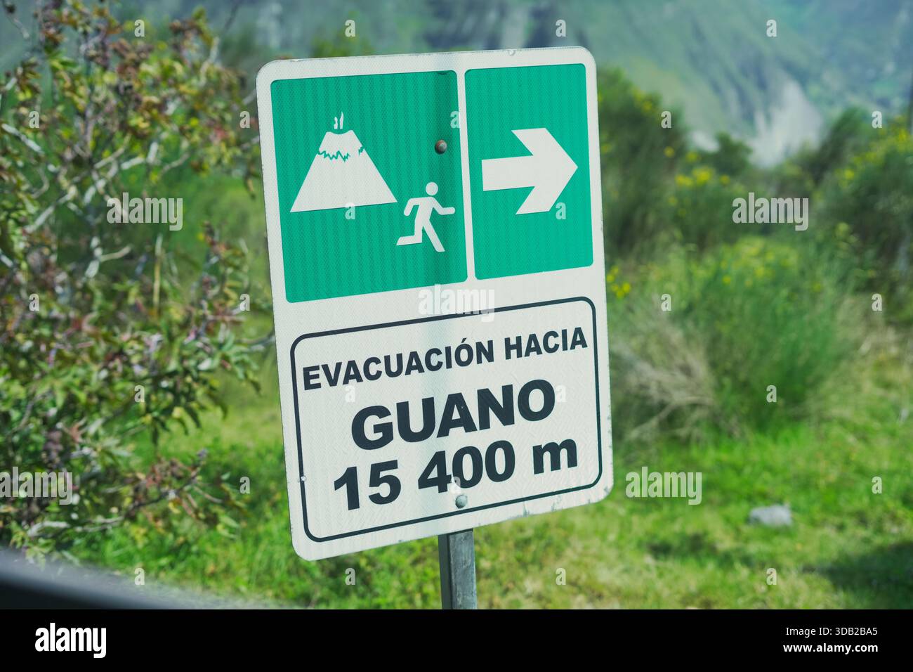 Green and white sign indicating a volcano evacuation route, featuring a ...