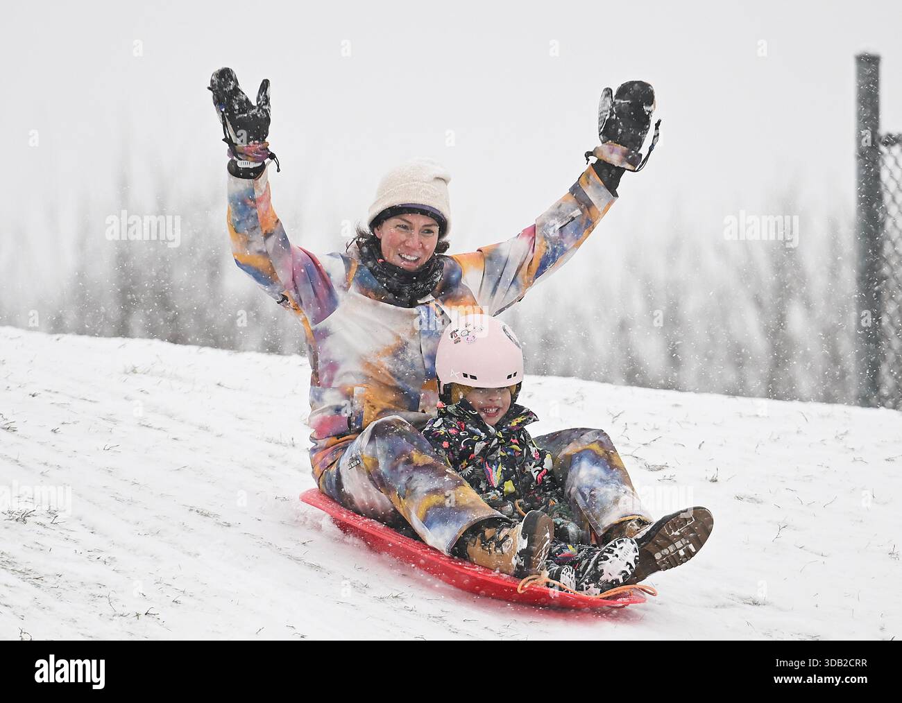 Rebecca Stuart and Charlie Diaz Stuart (3) slide down a hill in ...
