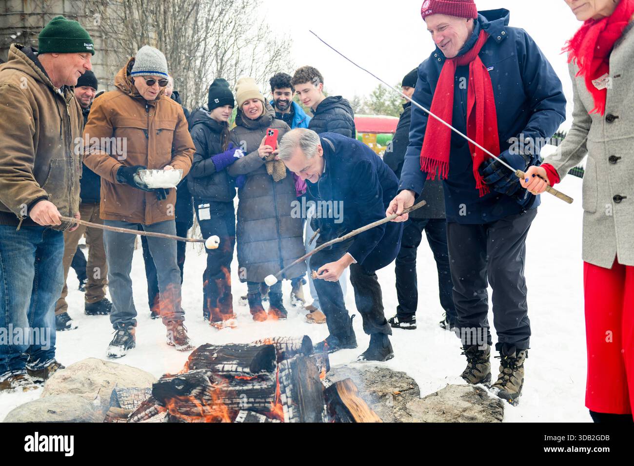 Prime Minister Mark Carney, centre, picks up a dropped marshmallow from ...