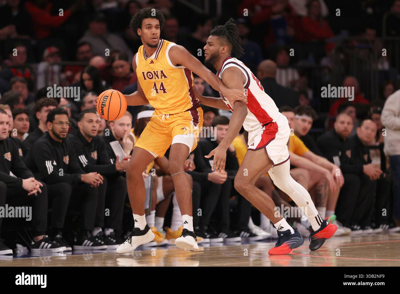 Iona's Alliou Fall (44) looks for an outlet against St. John's Zuby ...