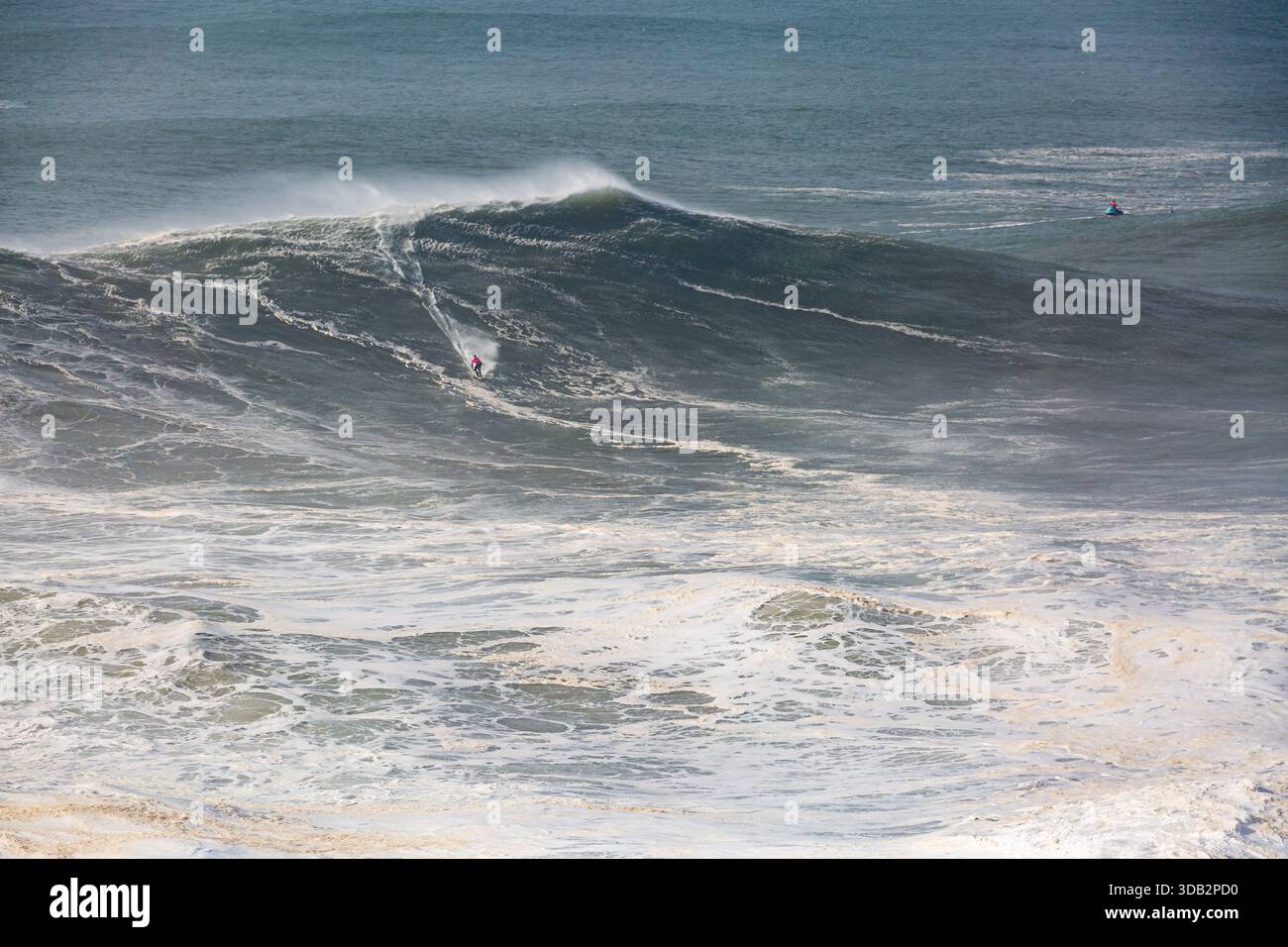 December 13, 2025, Nazare, Portugal: A surfer rides a towering wave ...