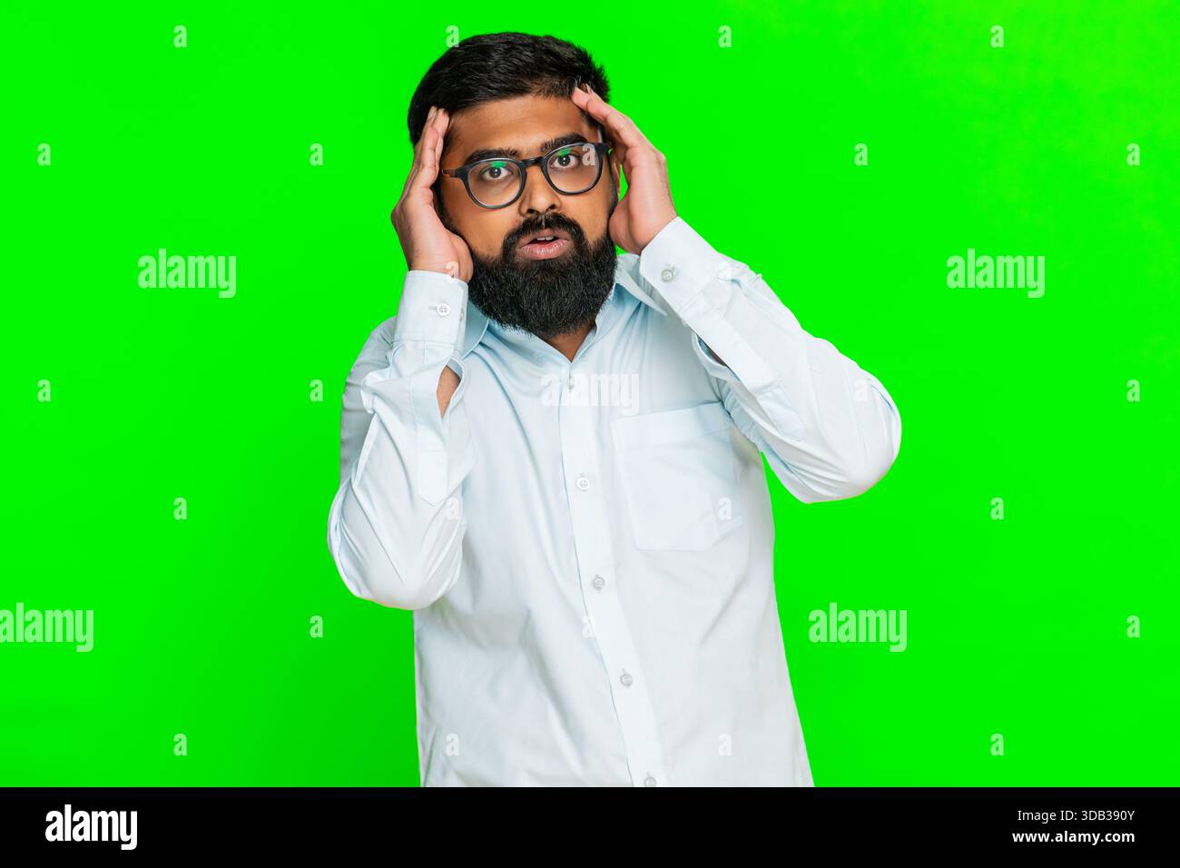 Indian man presses fingers to temples with tense face, simulating ...