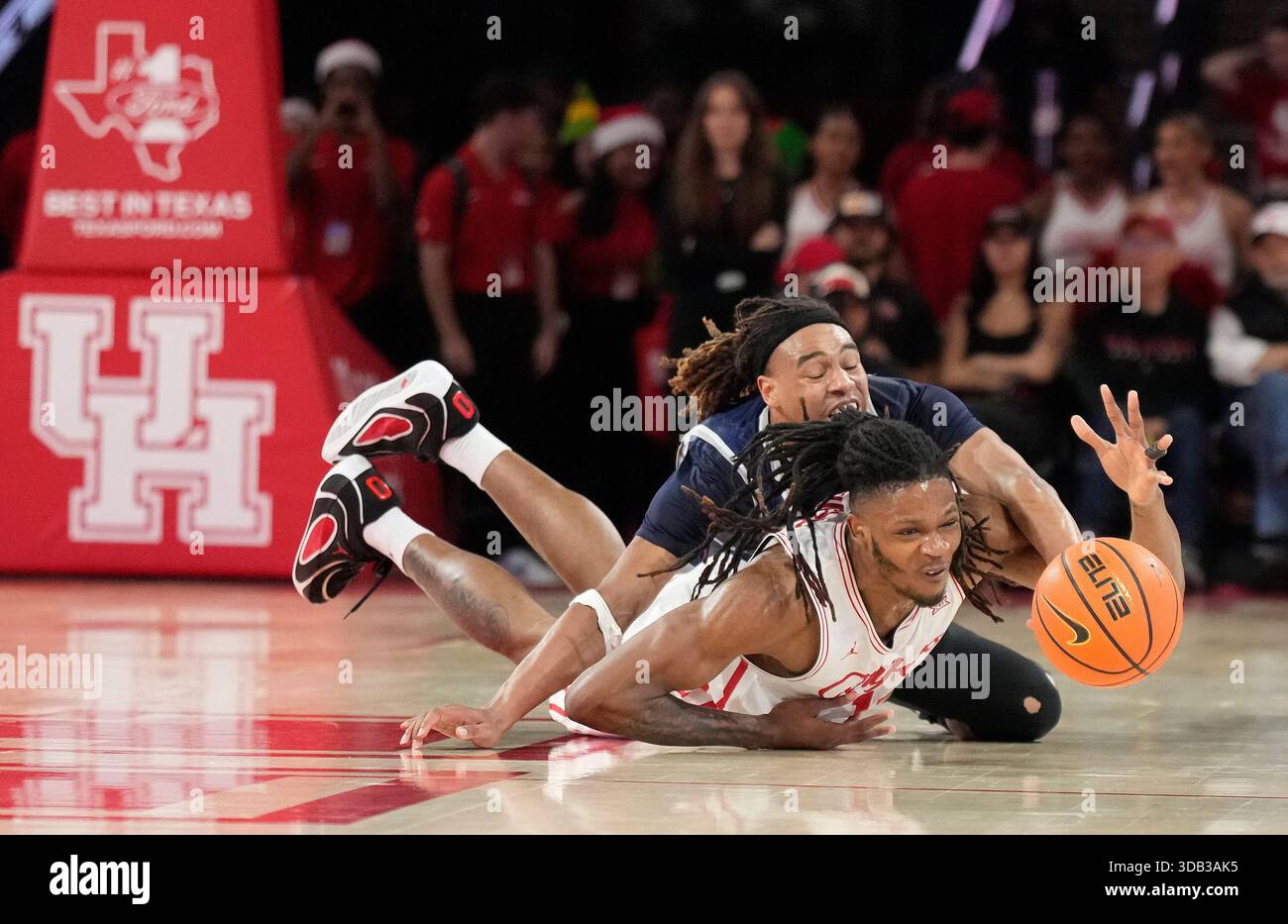 Houston forward Joseph Tugler, bottom, chases a loose ball against New ...