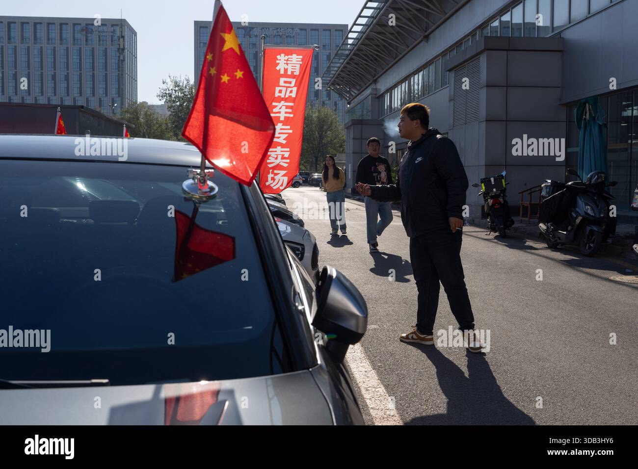 A man stands near second hand luxury cars for sale in Beijing on Friday ...