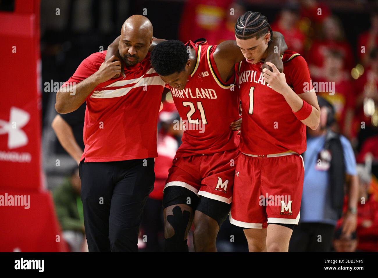 Maryland forward Pharrel Payne (21) is helped off the court by guard ...