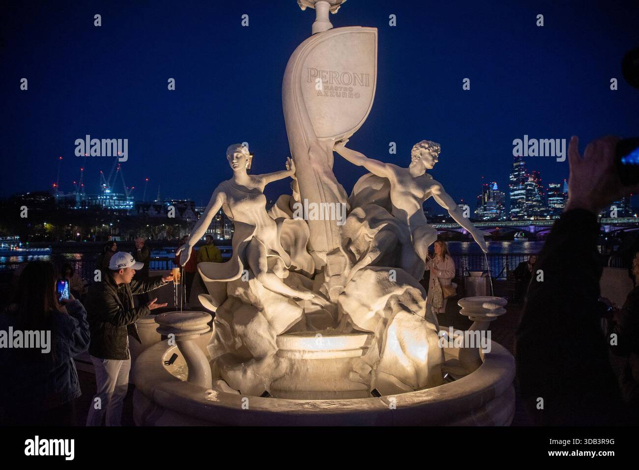 A guest fills up his glass with Peroni beer from the fountain at the ...