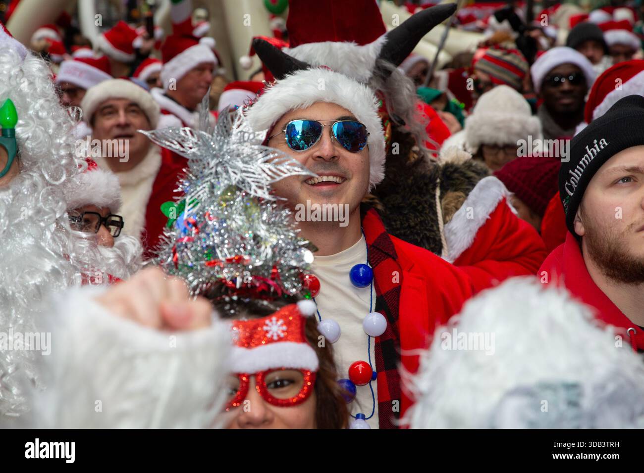 Revelers dressed in Santa Claus and other costumes participate in the ...