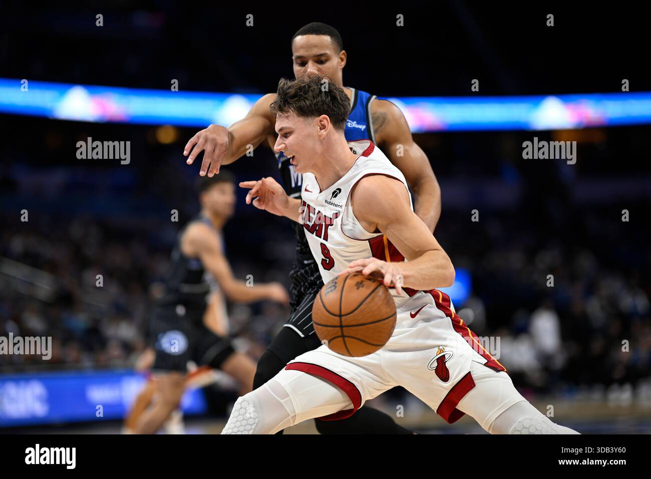 Miami Heat guard Pelle Larsson (9) is defended by Orlando Magic guard ...