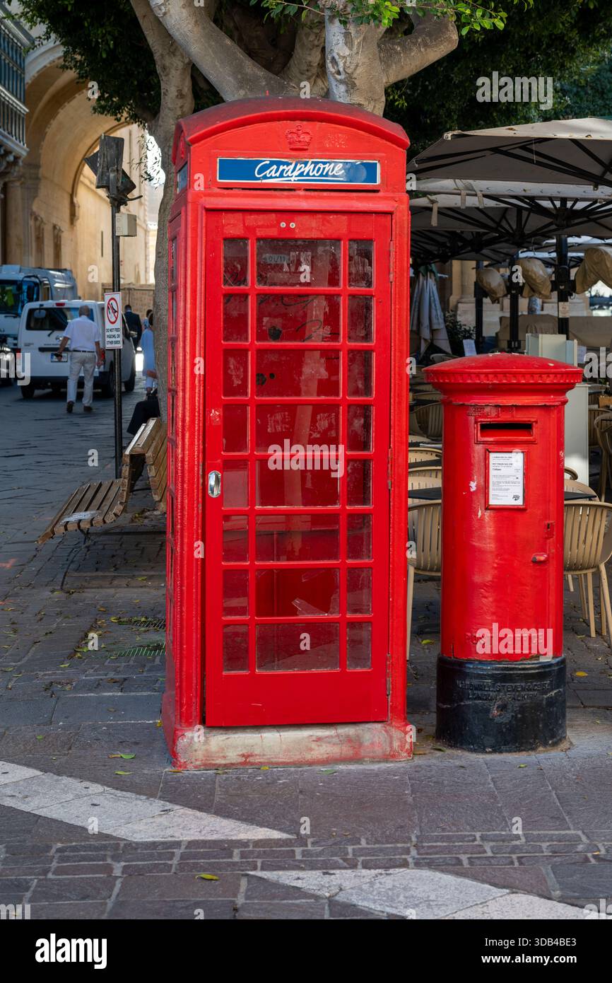 A classic red British phone booth and post box stand side-by-side in ...