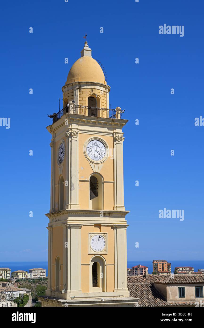 Historic yellow clock tower standing against a clear blue sky with a ...