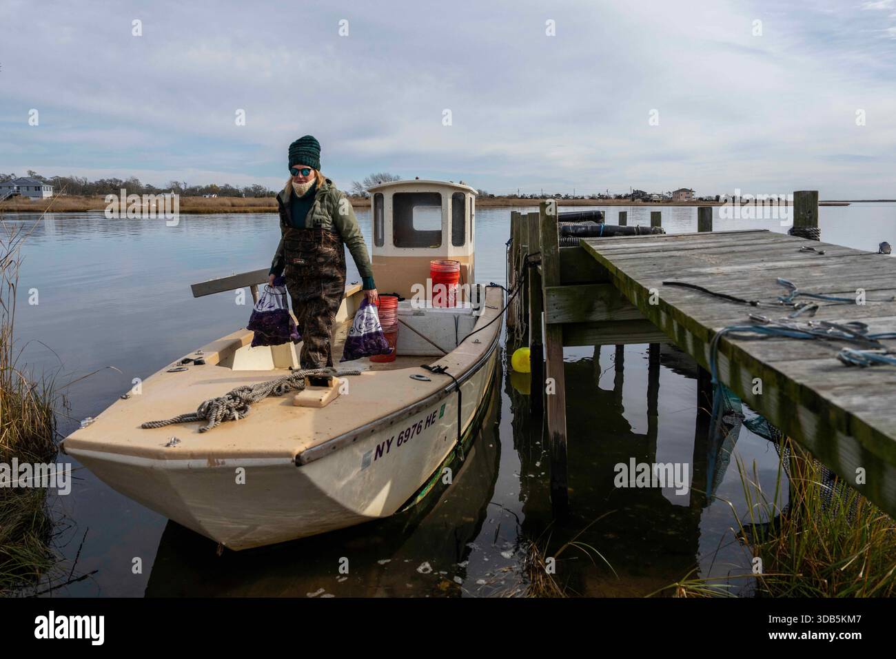 Retired WNBA star and Hall of Famer Sue Wicks carries bags of oysters ...