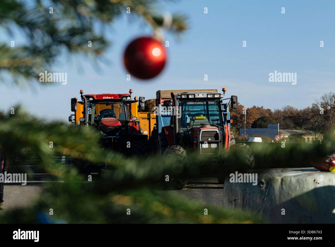 A Christmas tree with red baubles, with tractors belonging to farmers ...