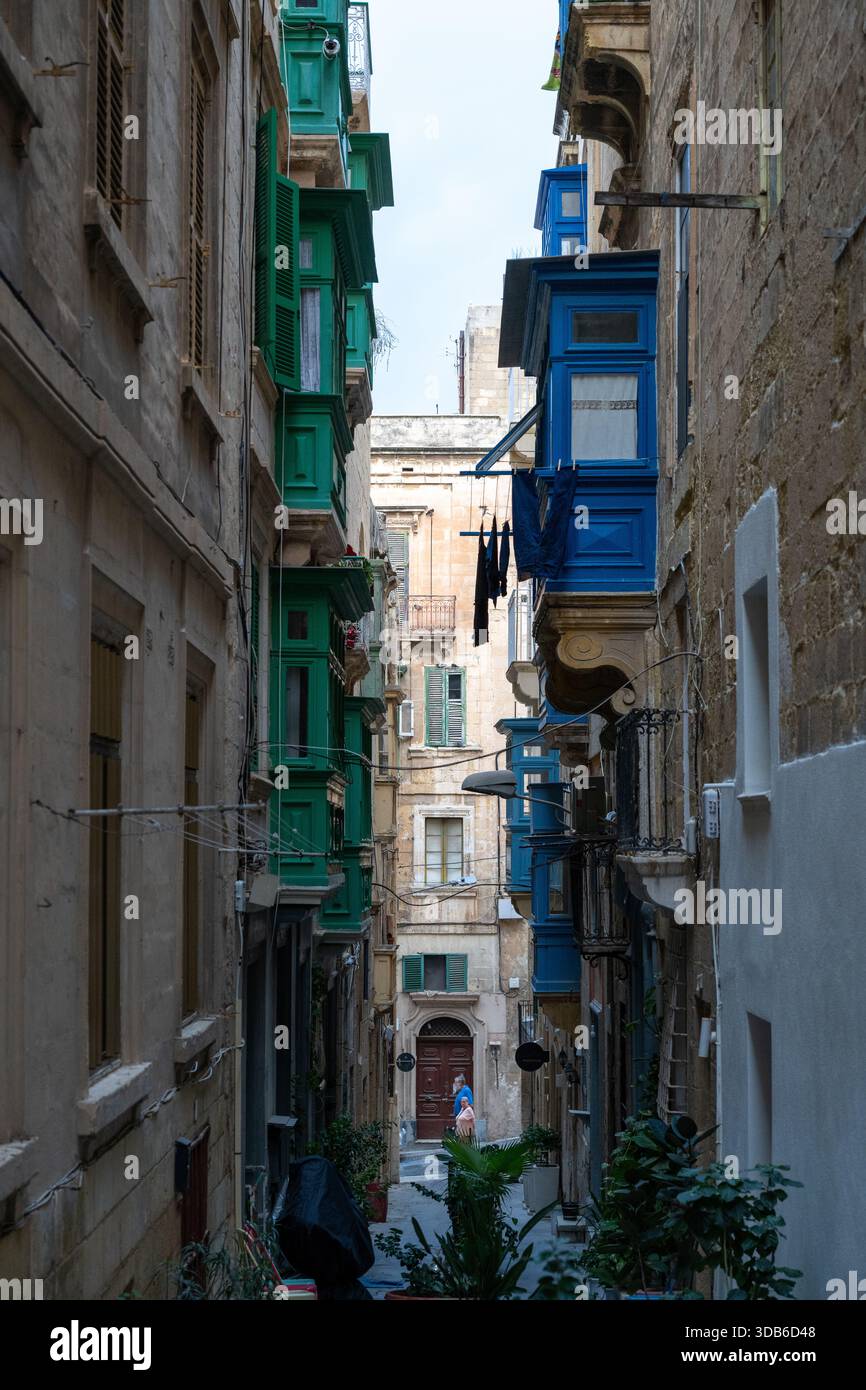 A narrow street in Valletta, Malta, is lined with colorful balconies ...
