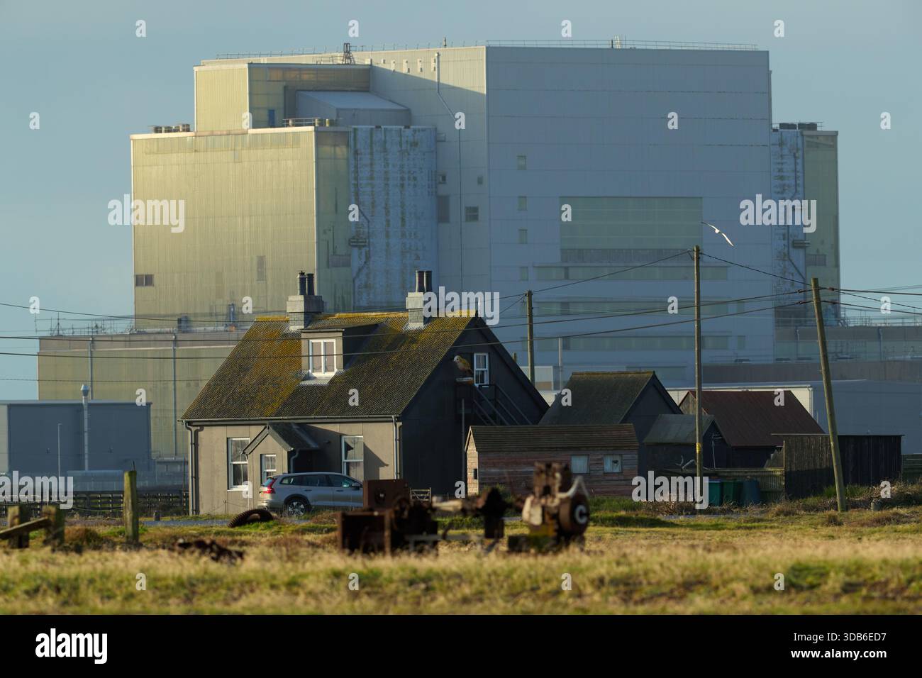 Dungeness Nuclear Power Station stands behind small beach houses on the ...
