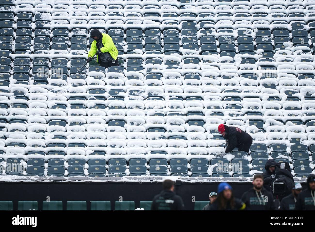 Snow is cleared from seats before an NFL football game between the ...