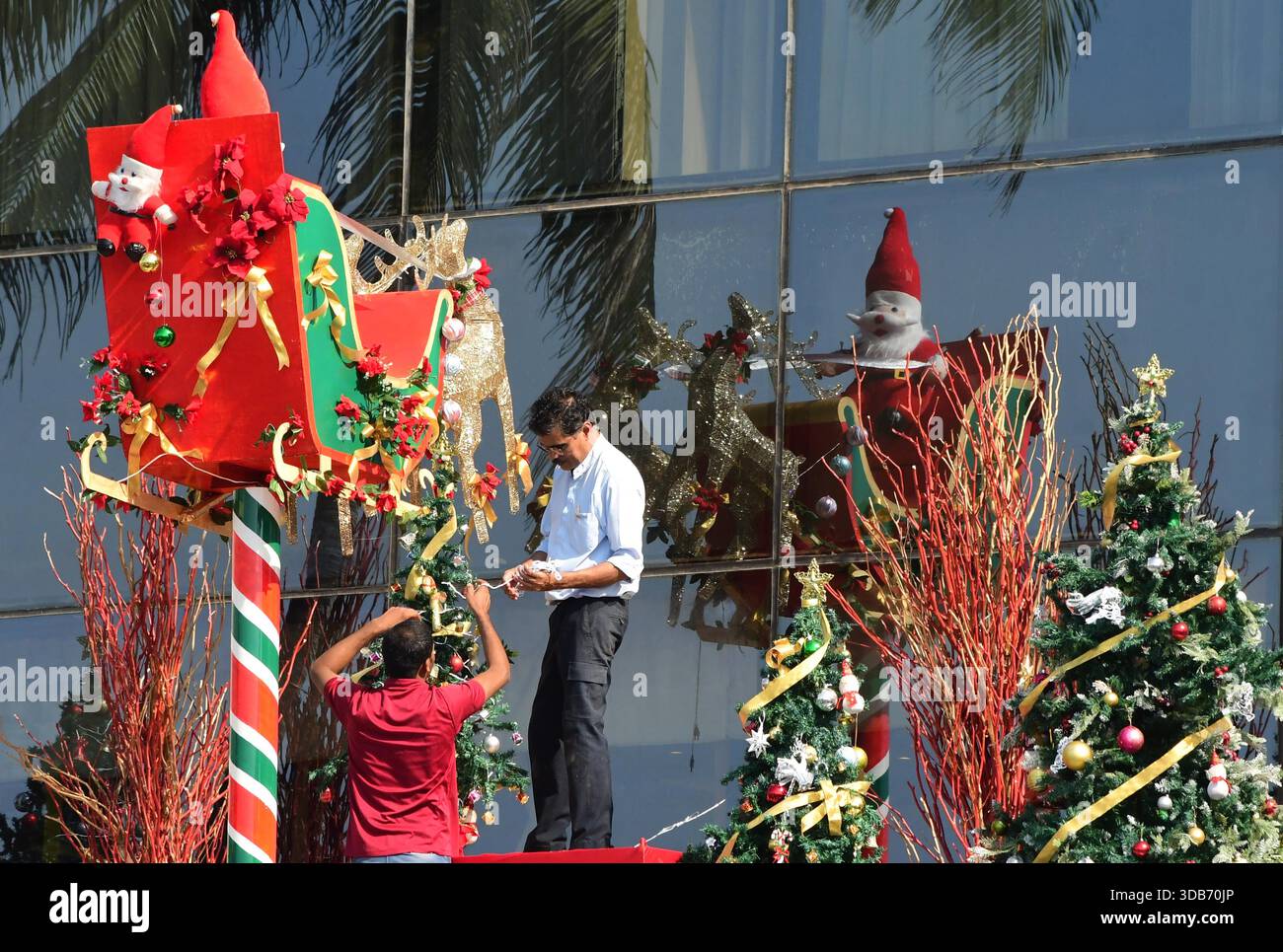 MUMBAI, INDIA - DECEMBER 13: Worker installing the Santa and decorating ...