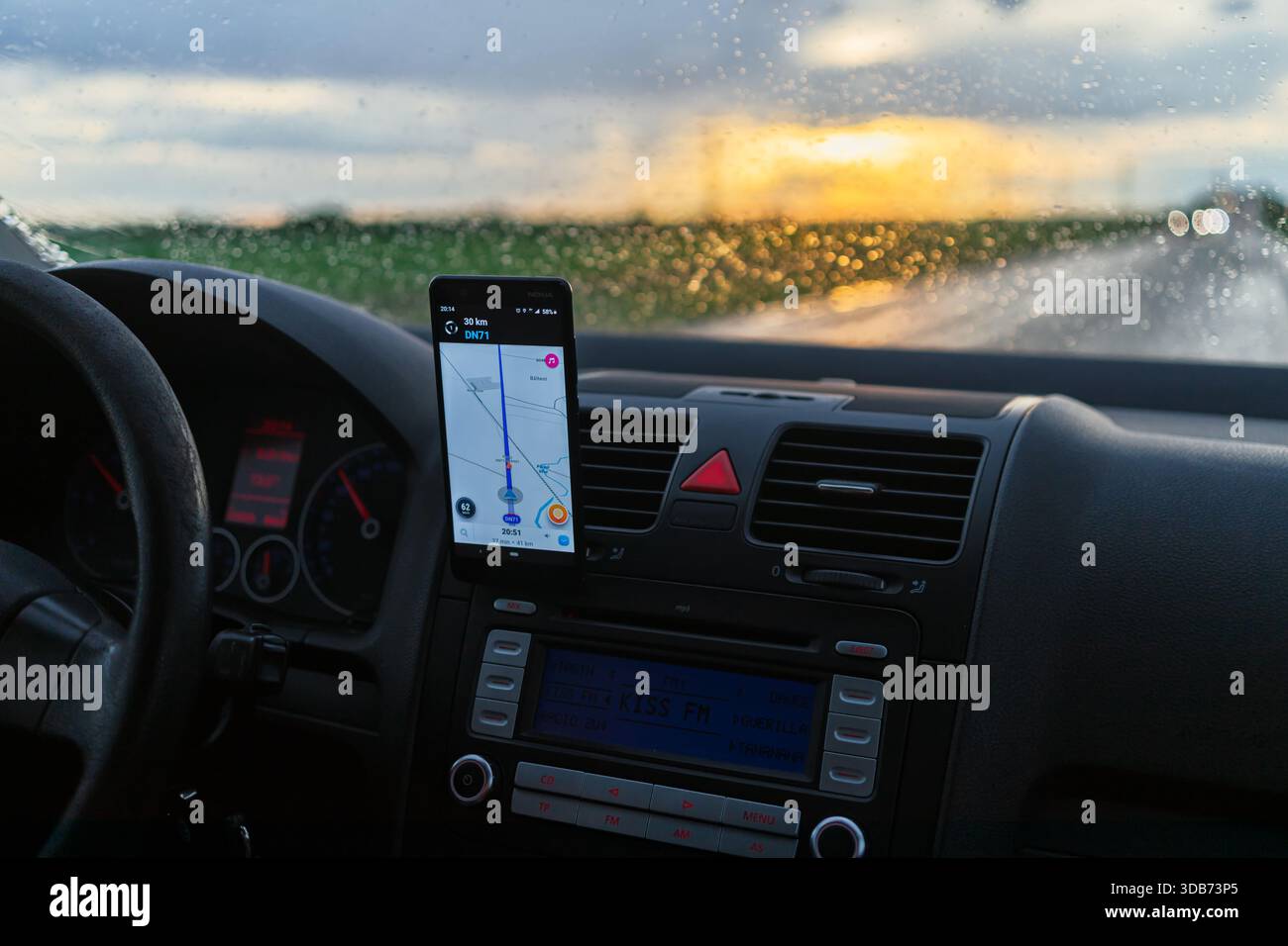 Driver using waze app on mobile phone mounted on car dashboard Stock ...