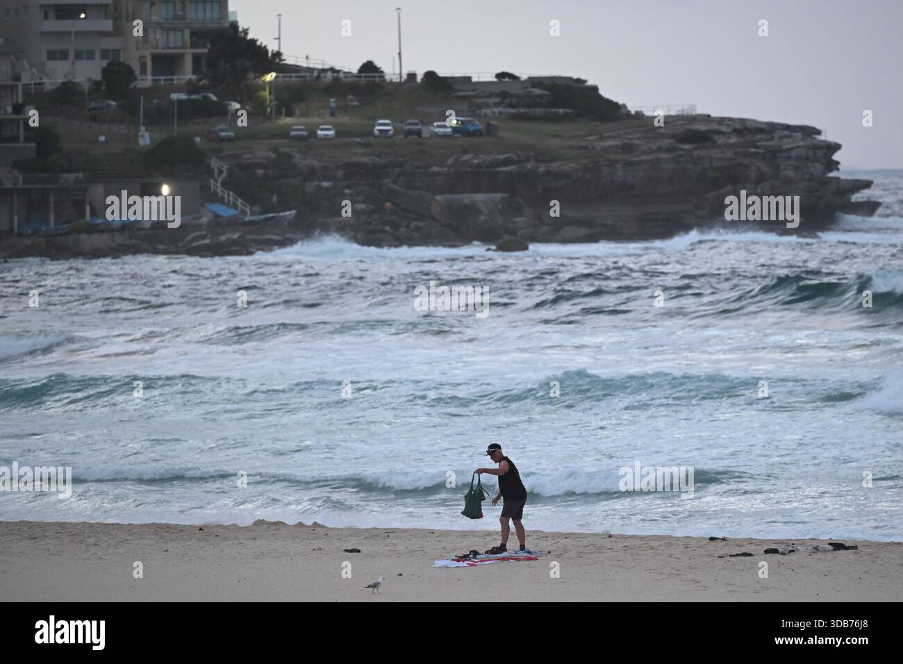 A man moves discarded beach equipment and personal belongings as the ...