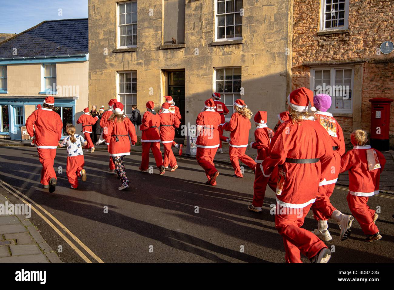 Group of people dressed in Santa Claus costumes running through a ...