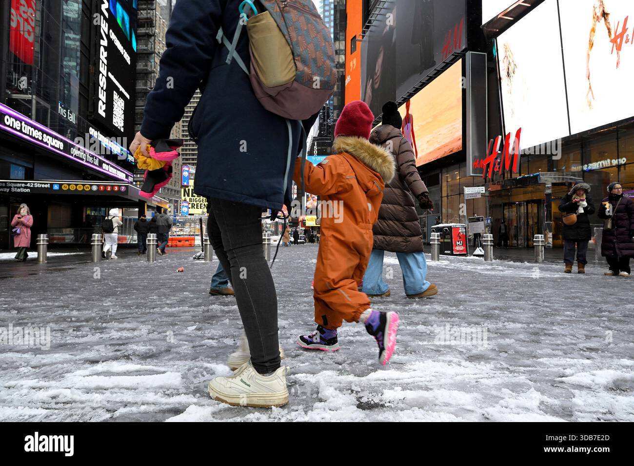 New York, USA. 14th Dec, 2025. People walk through melting snow in ...